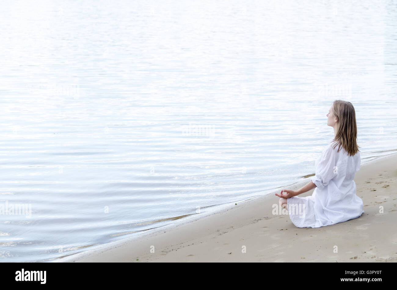 Woman meditating at the sea Stock Photo - Alamy