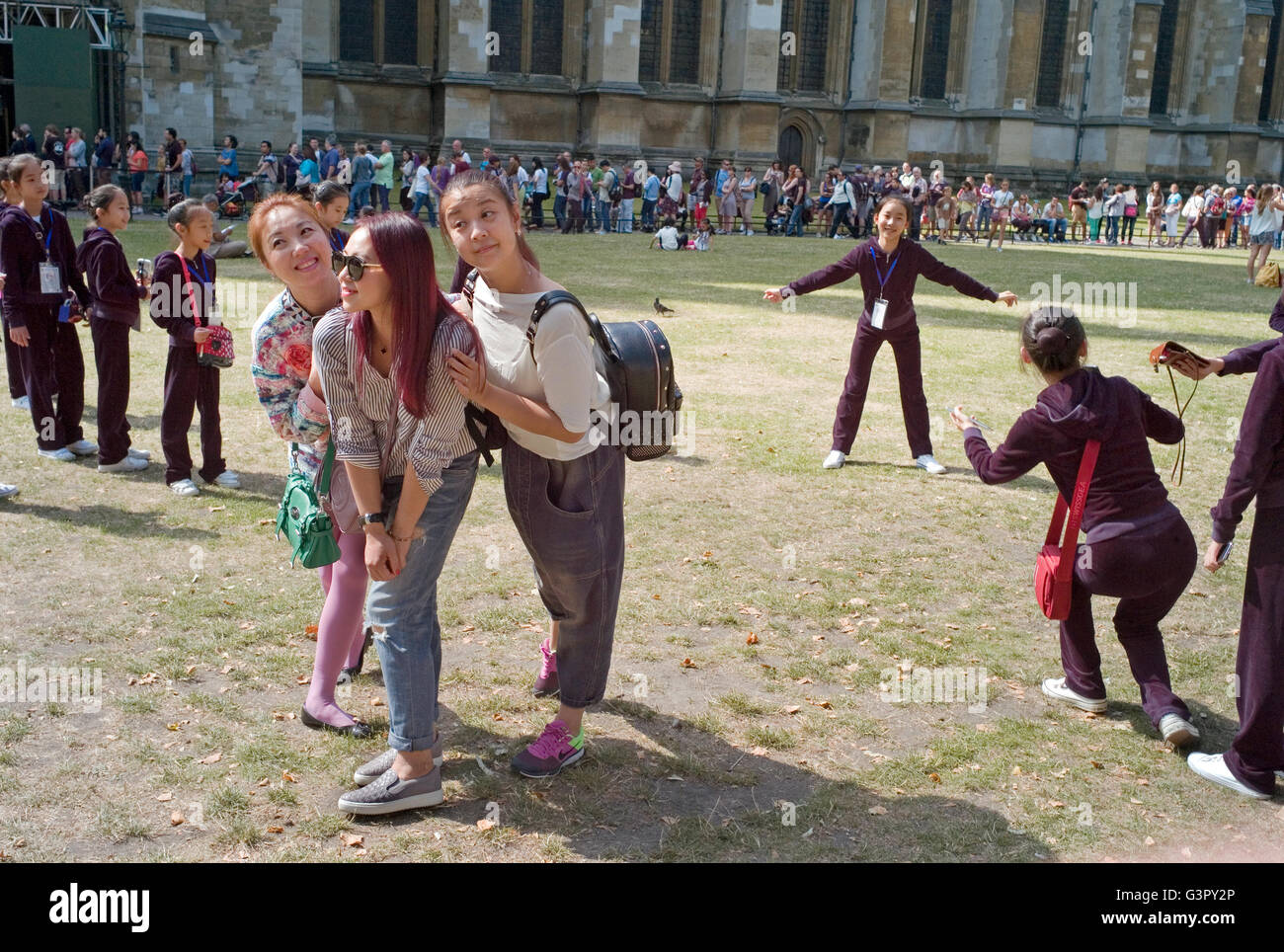 A group of Chinese Tourists taking photographs of themselves pointing ...