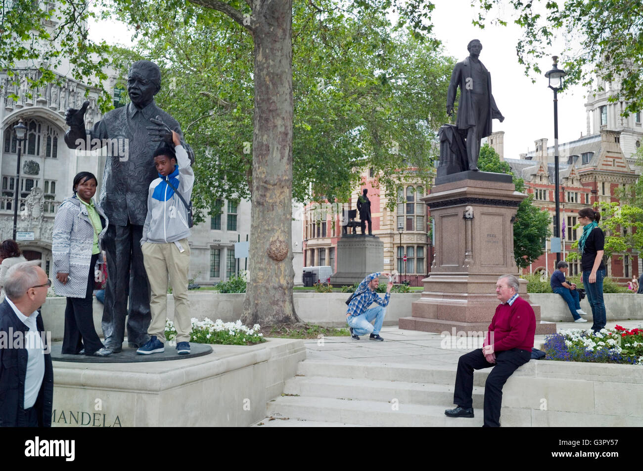 A group of Tourists standing and posing around the statues on ...