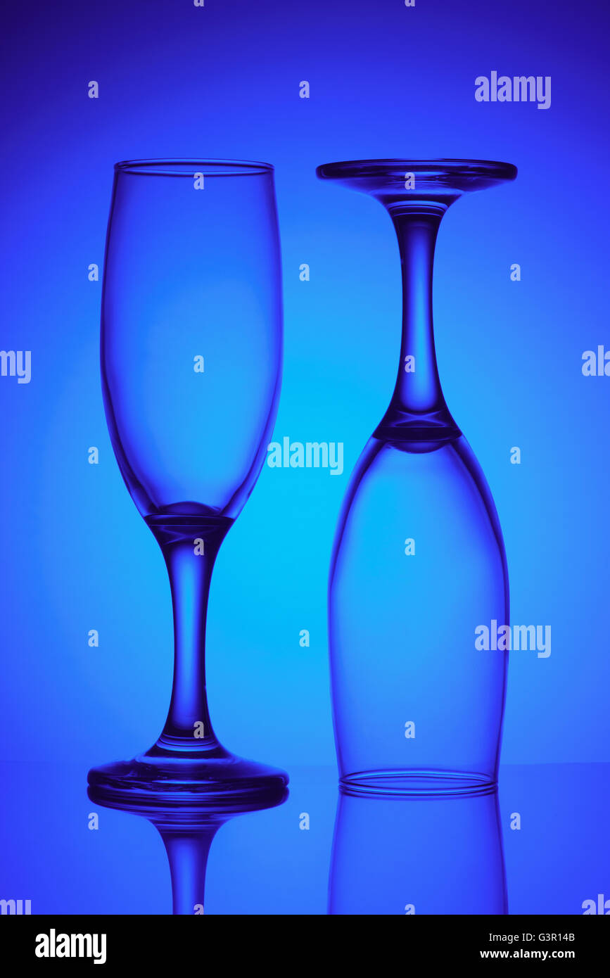 Two empty glasses in blue light Stock Photo - Alamy