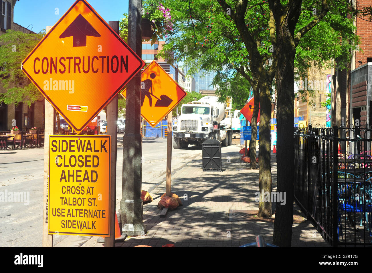 Closed sidewalk and construction signs on the side of the street in ...