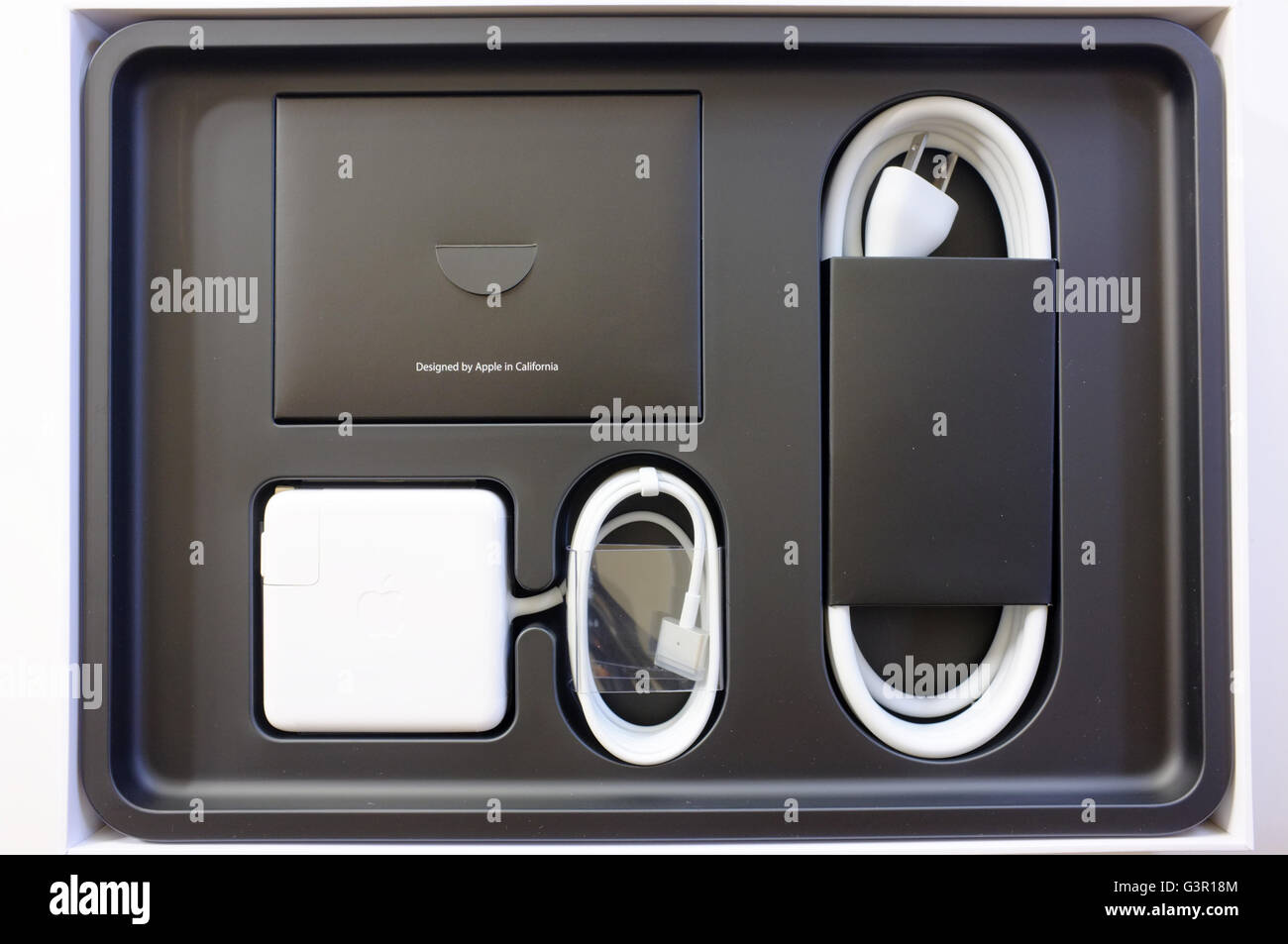 MacBook cables in their box photographed against a white background ...