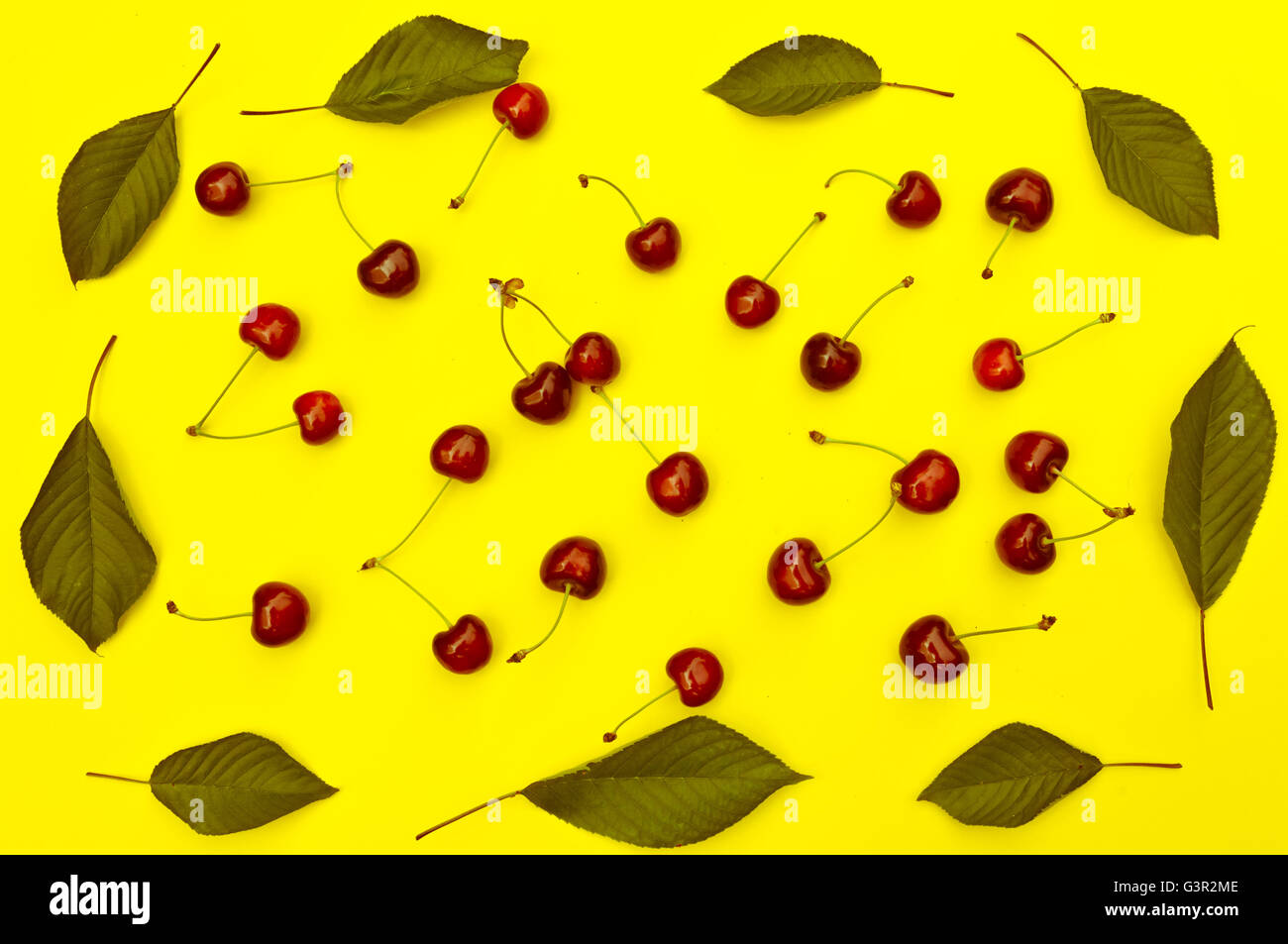 Cherry, cherries with cherry leaves on yellow background, top view ...