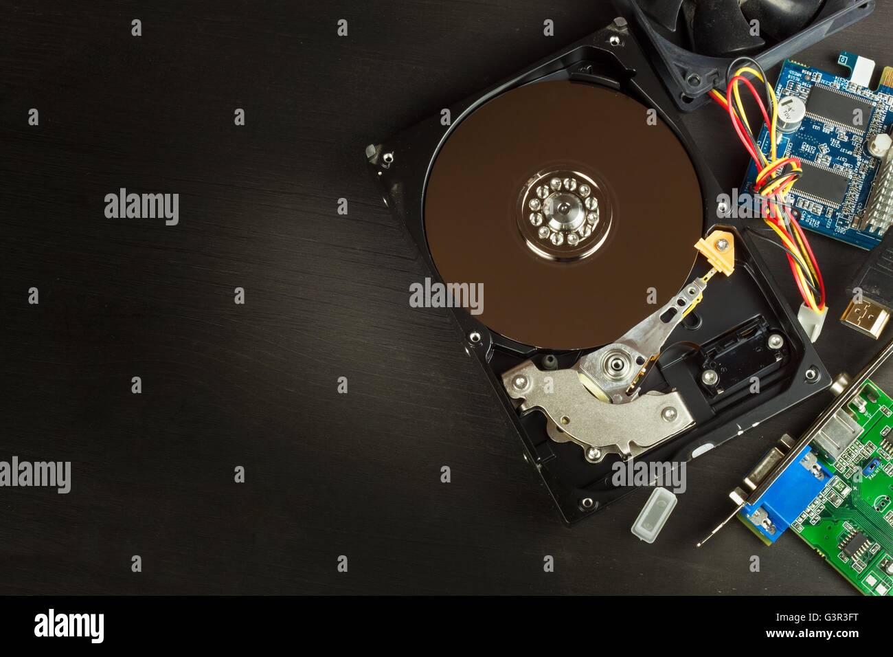 Open hard drive on a black wooden background. Production of computers ...