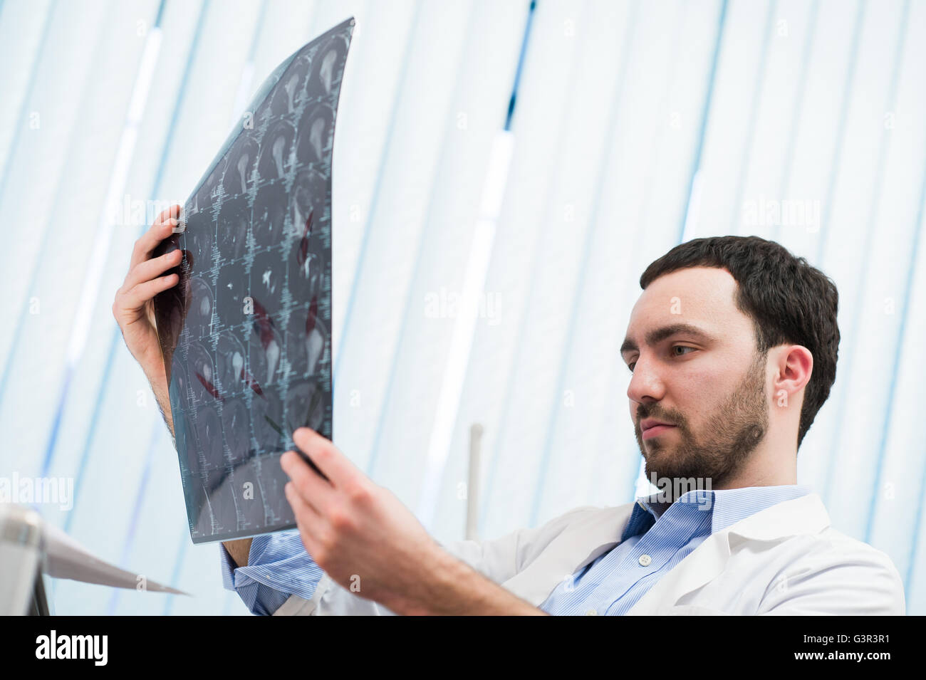 Young male physician reading and reviewing a MRI brain scan Stock Photo ...