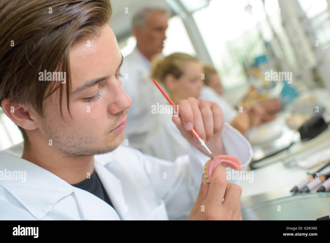 Young man manufacturing false teeth Stock Photo - Alamy