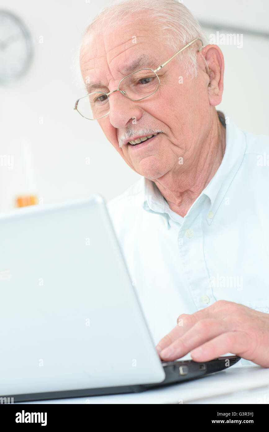 Elderly gentleman using a laptop Stock Photo - Alamy