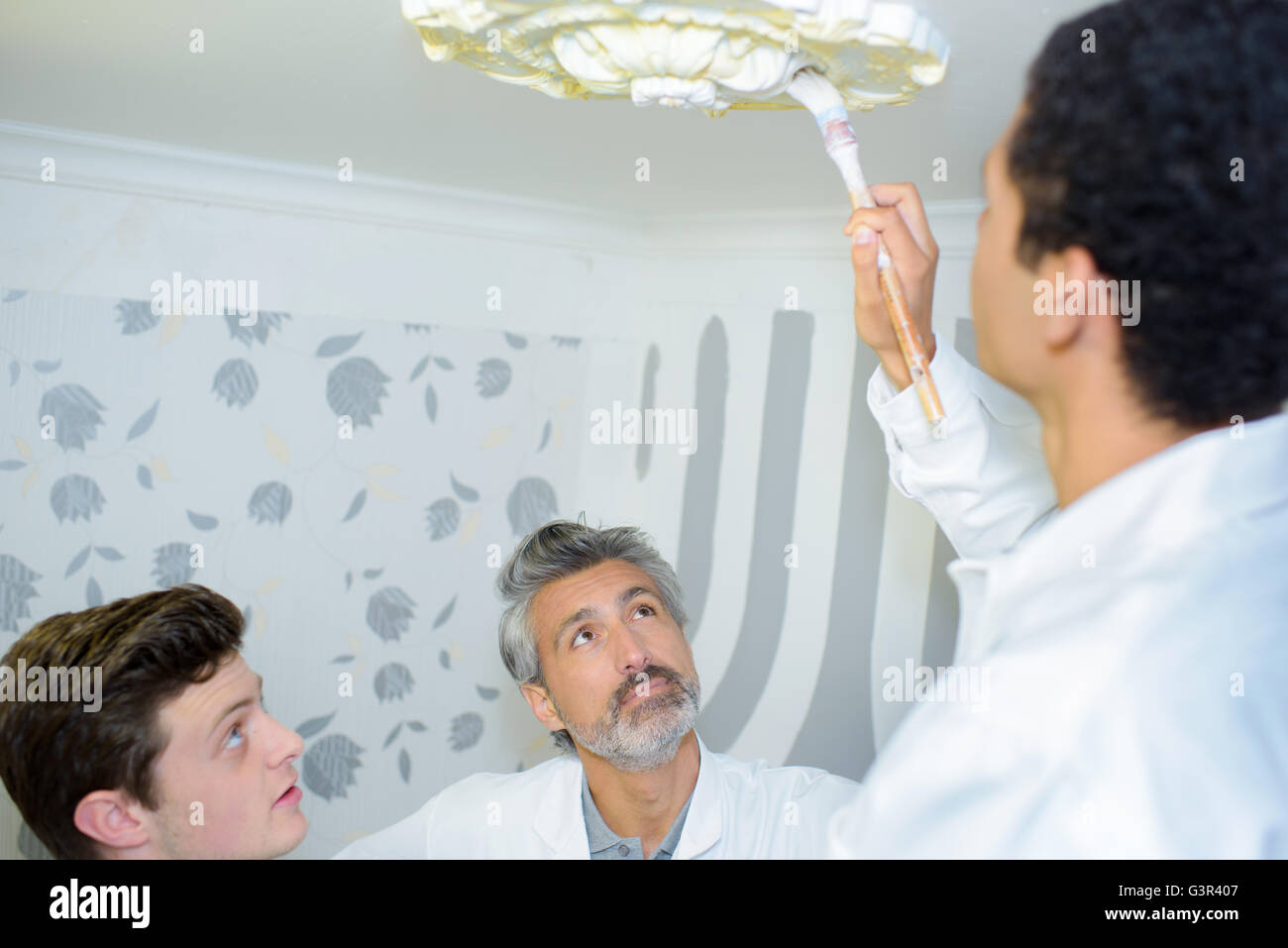 young man painting a decoration on the ceiling Stock Photo - Alamy