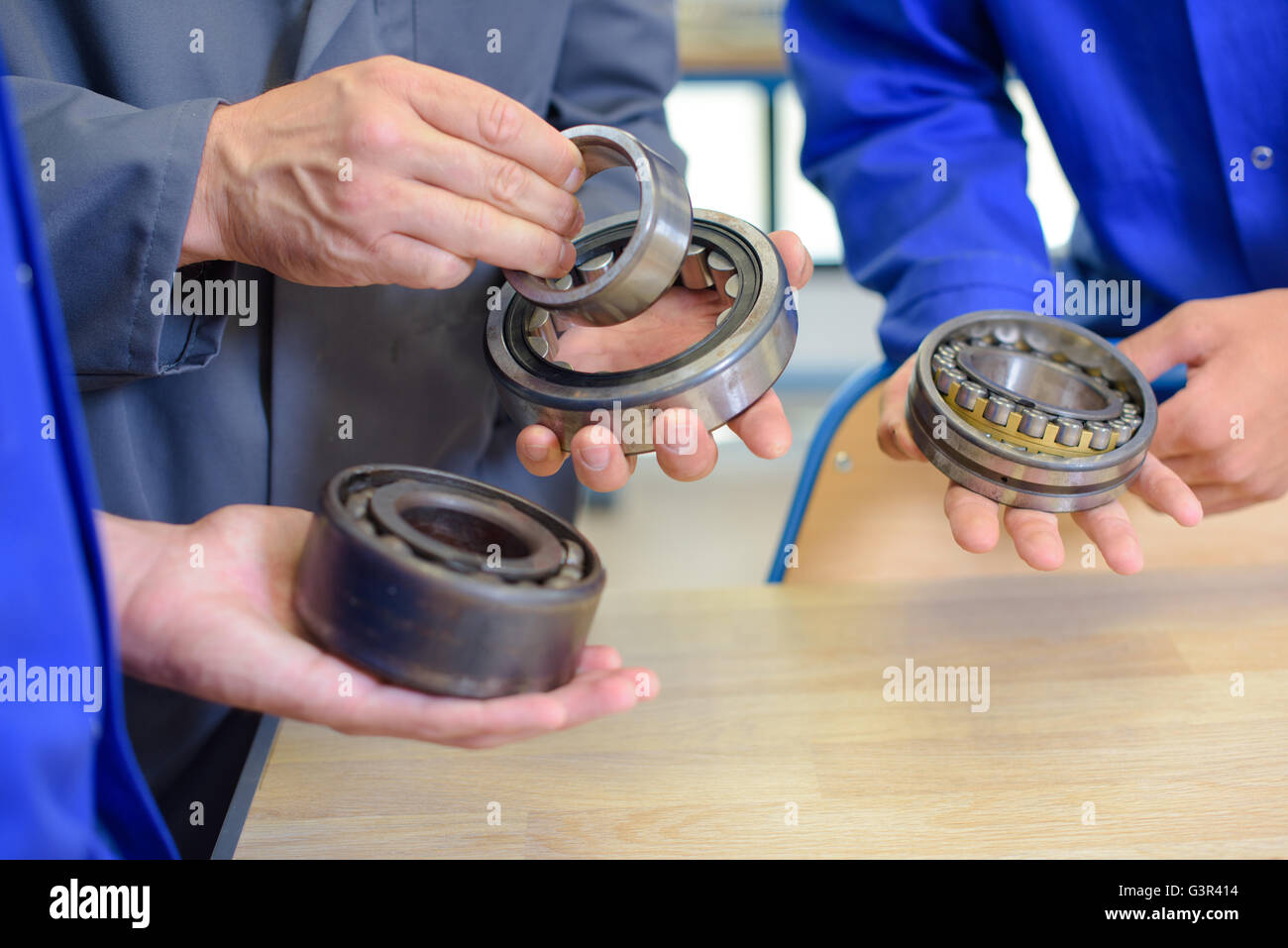 Three men holding bearings Stock Photo - Alamy