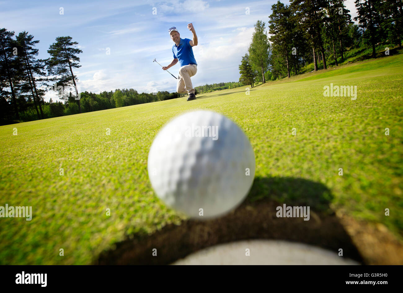 Ball rolling into the hole Stock Photo - Alamy