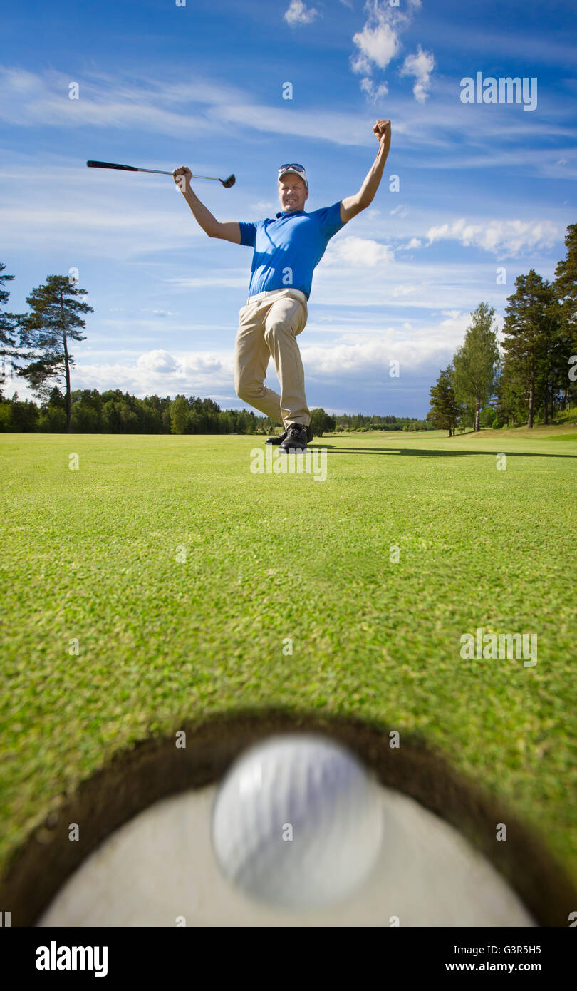 Ball rolling into the hole Stock Photo - Alamy