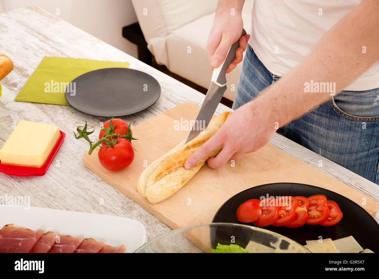 A young man preparing a sandwich in the kitchen Stock Photo - Alamy