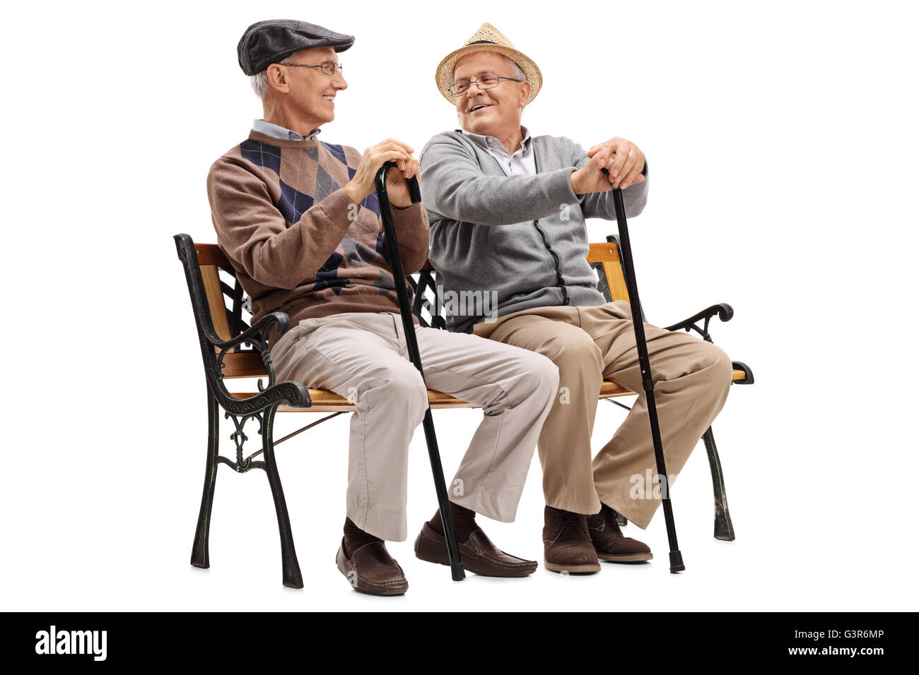 Two elderly men sitting on a wooden bench and talking to each other ...