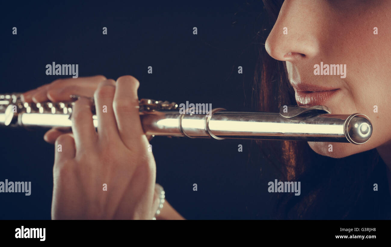 Music and elegance. Alluring elegant woman playing on transverse flute ...