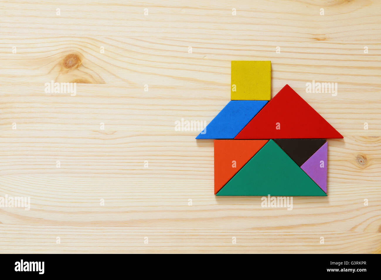 house made from tangram puzzle over wooden table. retro style image ...