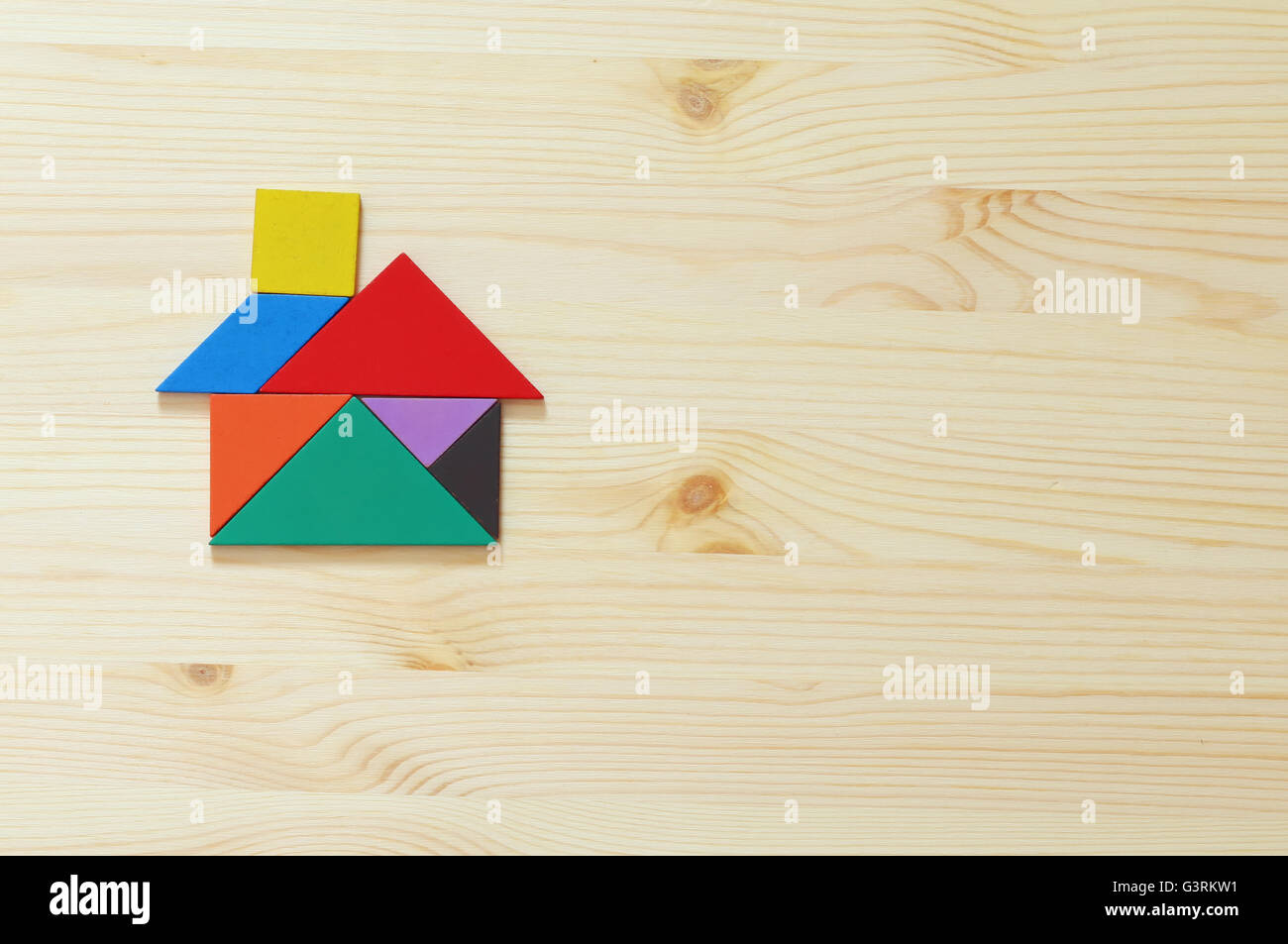 house made from tangram puzzle over wooden table. retro style image ...
