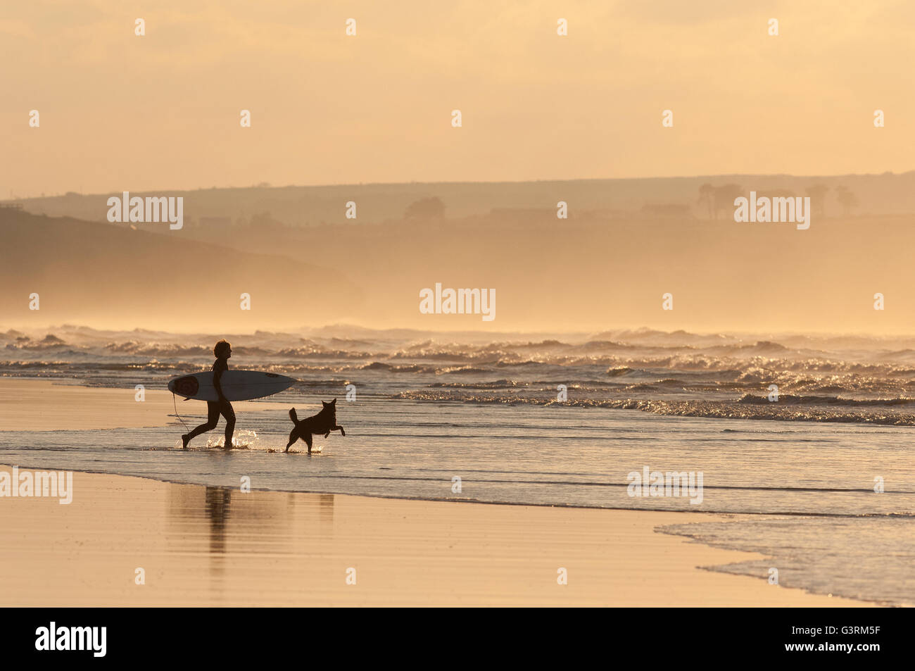 Single Surfer carrying surfboard running into the surf with his Stock ...