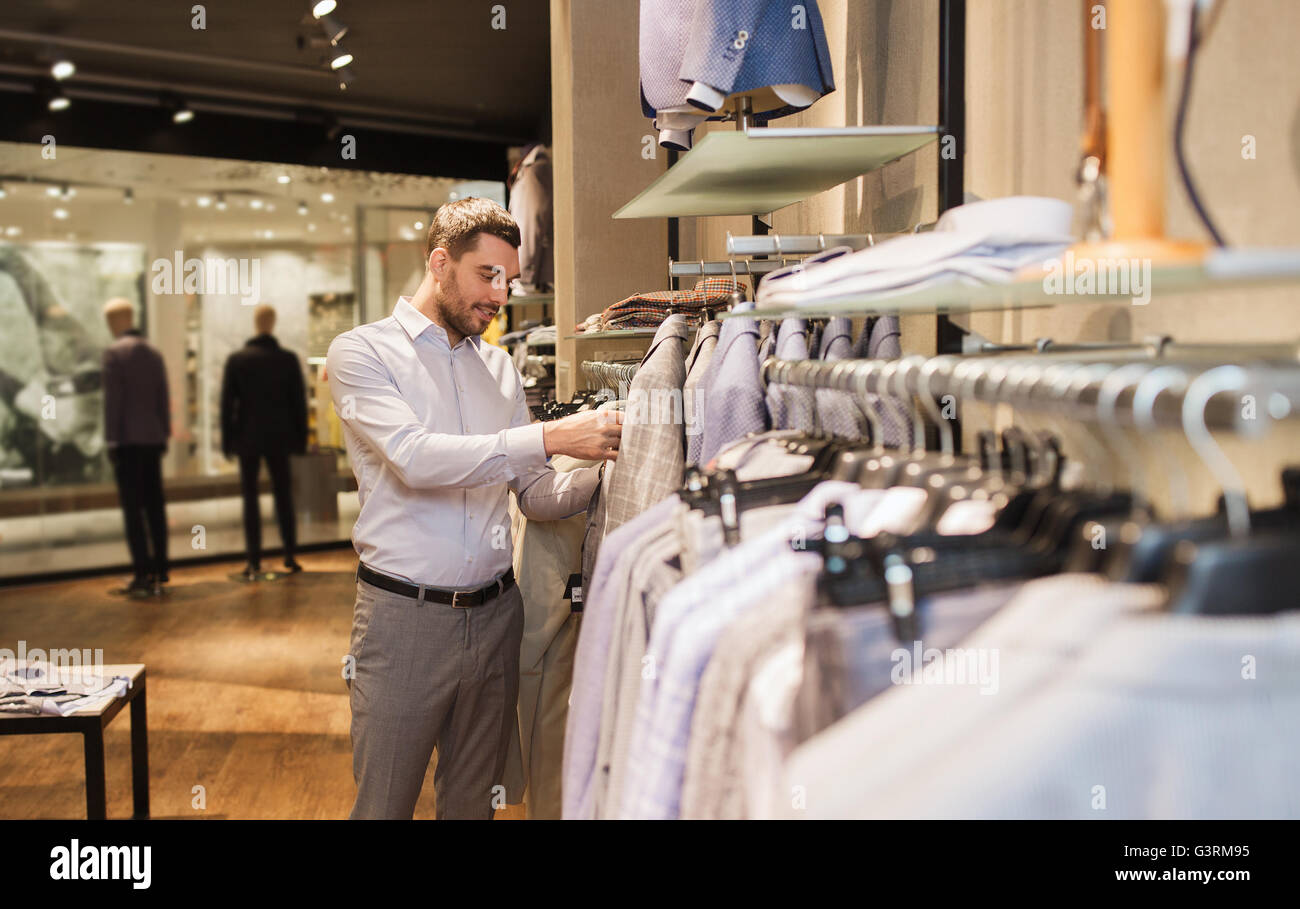 happy young man choosing clothes in clothing store Stock Photo - Alamy