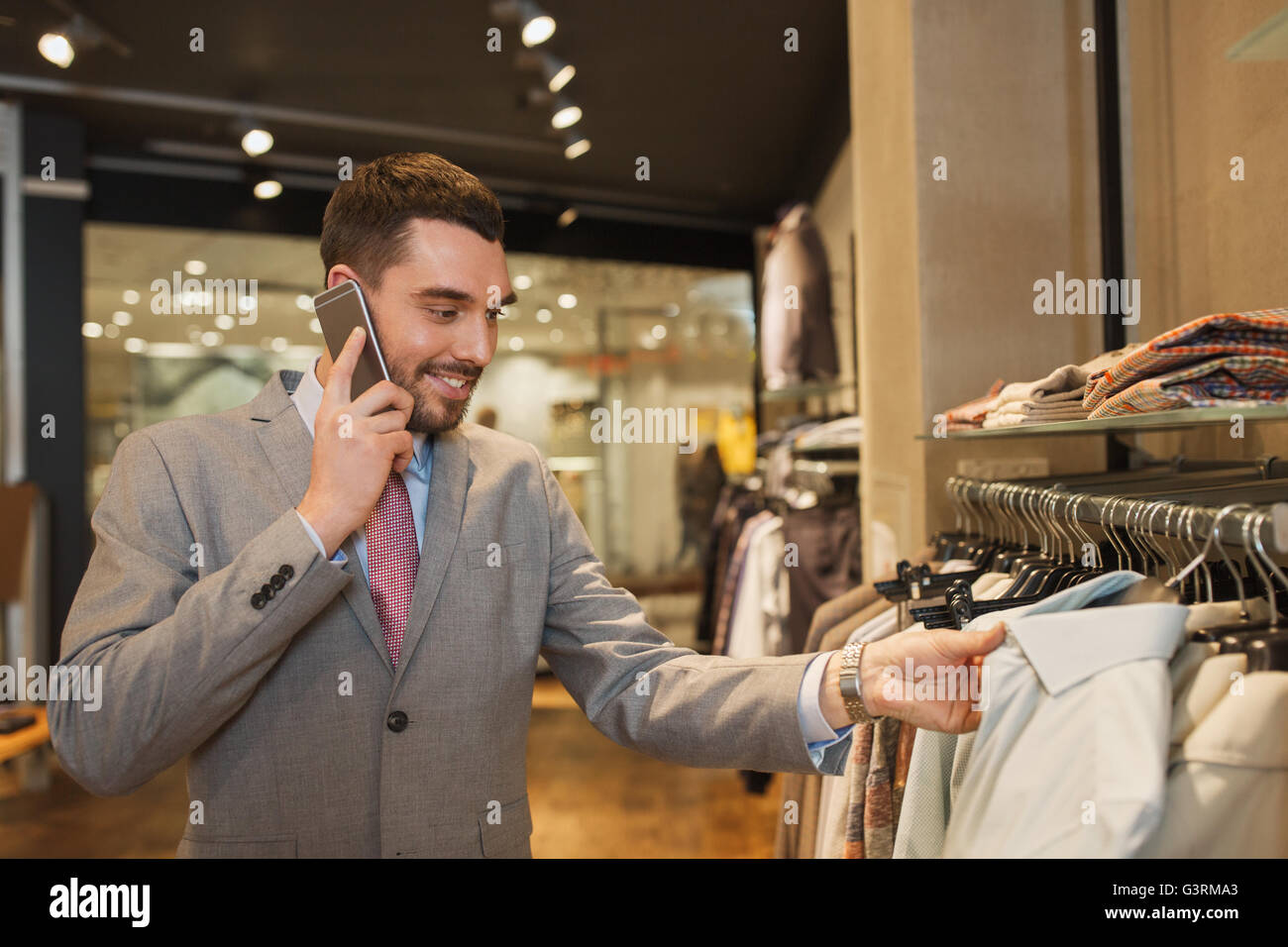 happy man calling on smartphone at clothing store Stock Photo - Alamy