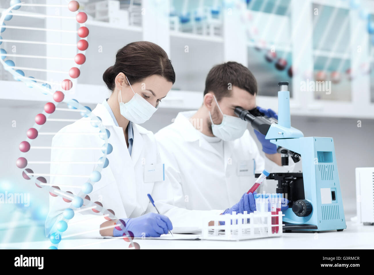 scientists with clipboard and microscope in lab Stock Photo - Alamy