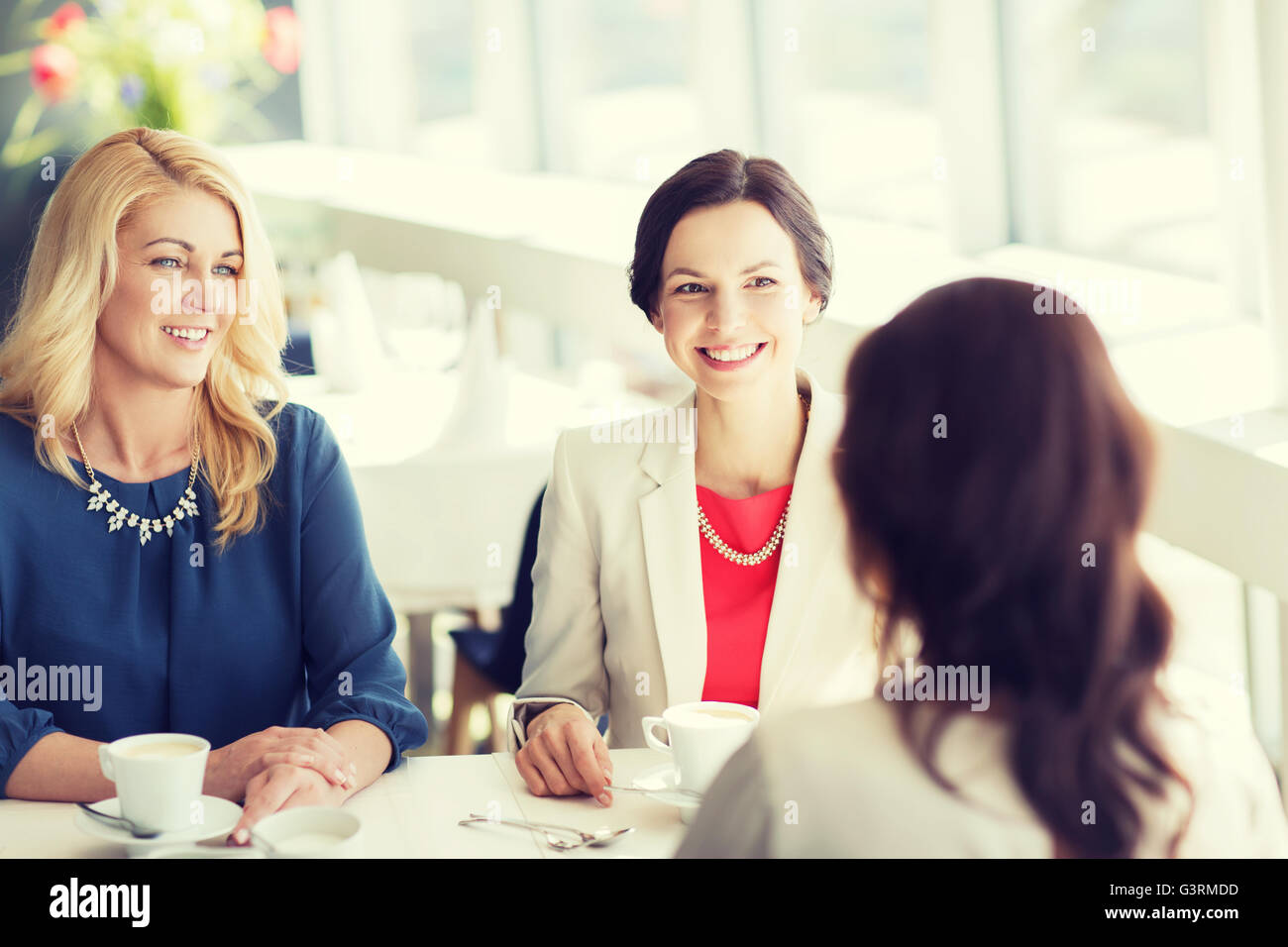 women drinking coffee and talking at restaurant Stock Photo - Alamy