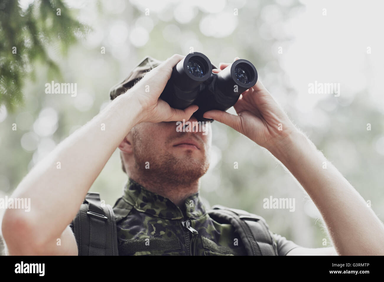 young soldier or hunter with binocular in forest Stock Photo - Alamy