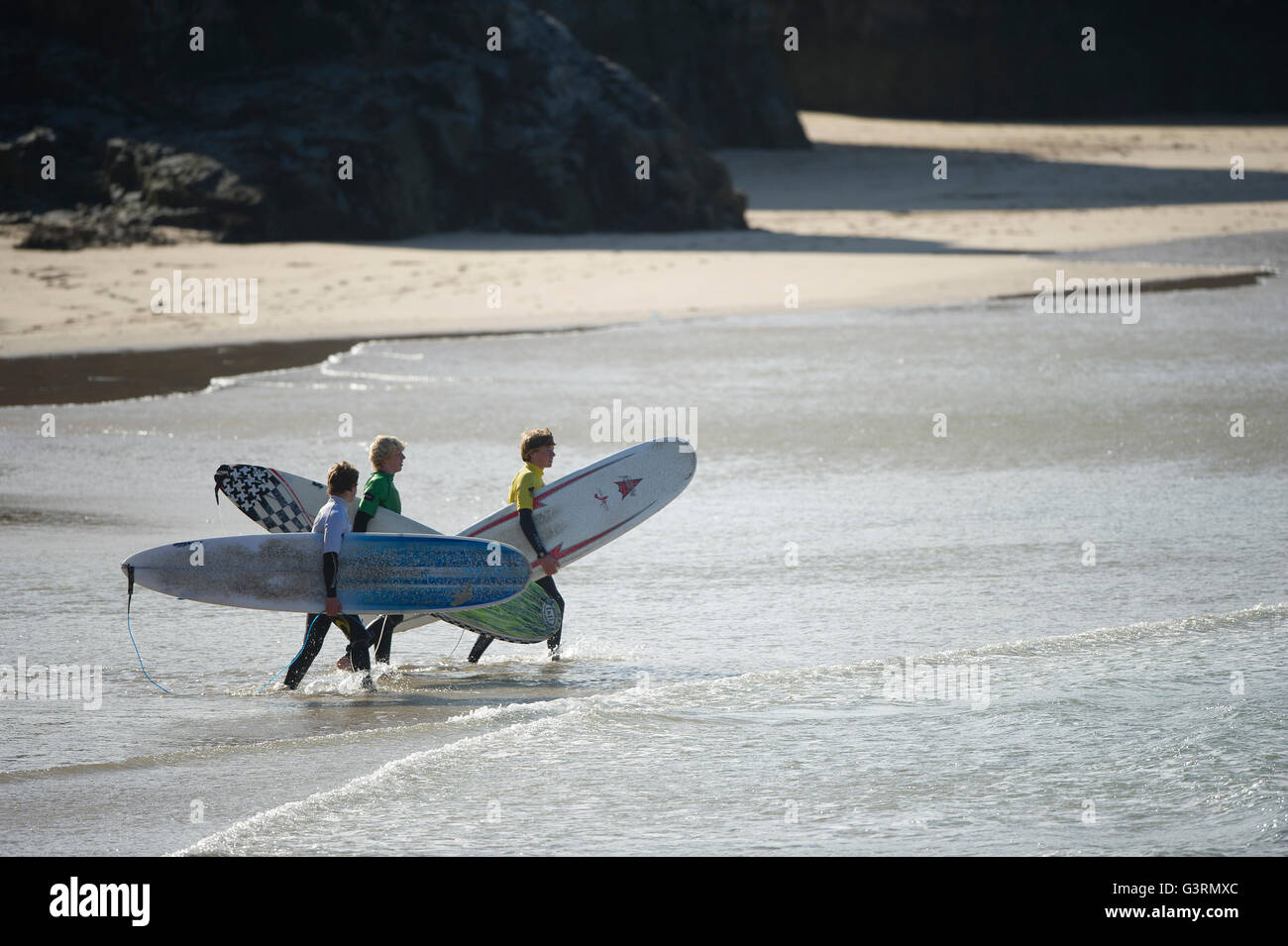 Three Surfers running into the surf Stock Photo - Alamy