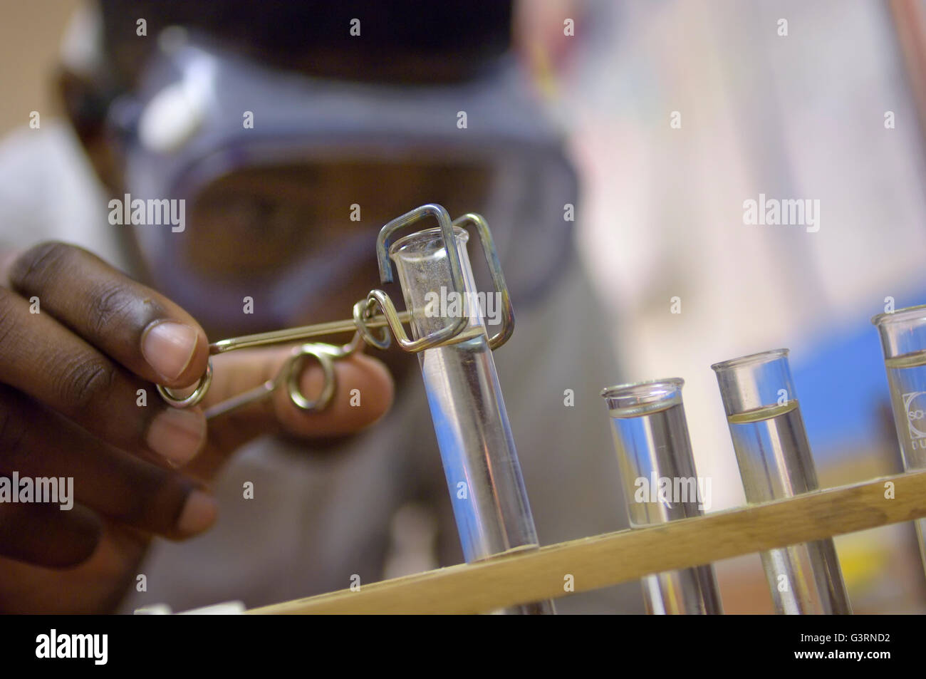 A male pupil holding a test tube during science lesson experiment ...