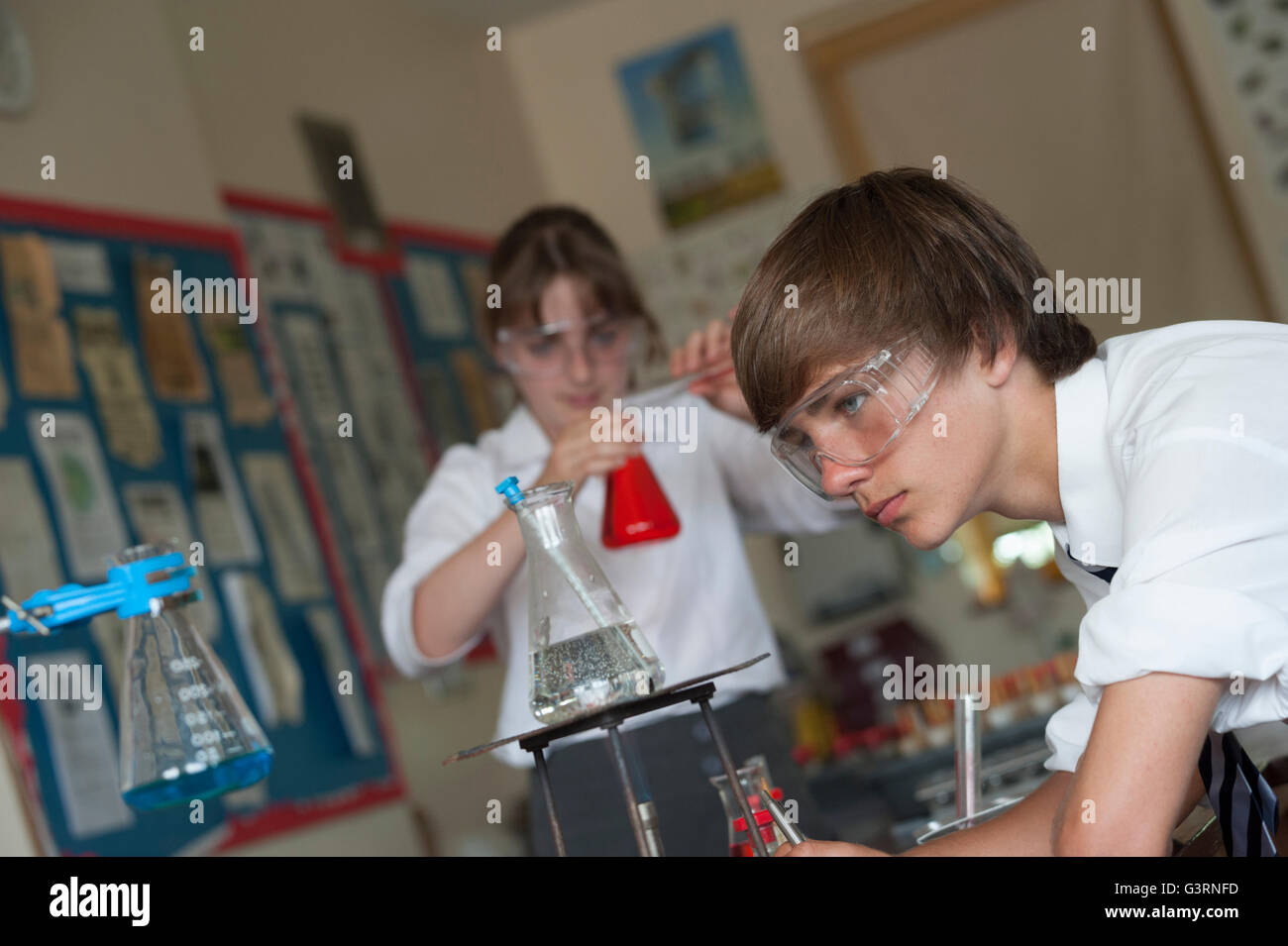 Secondary school lab partners taking part in a chemistry experiment in ...