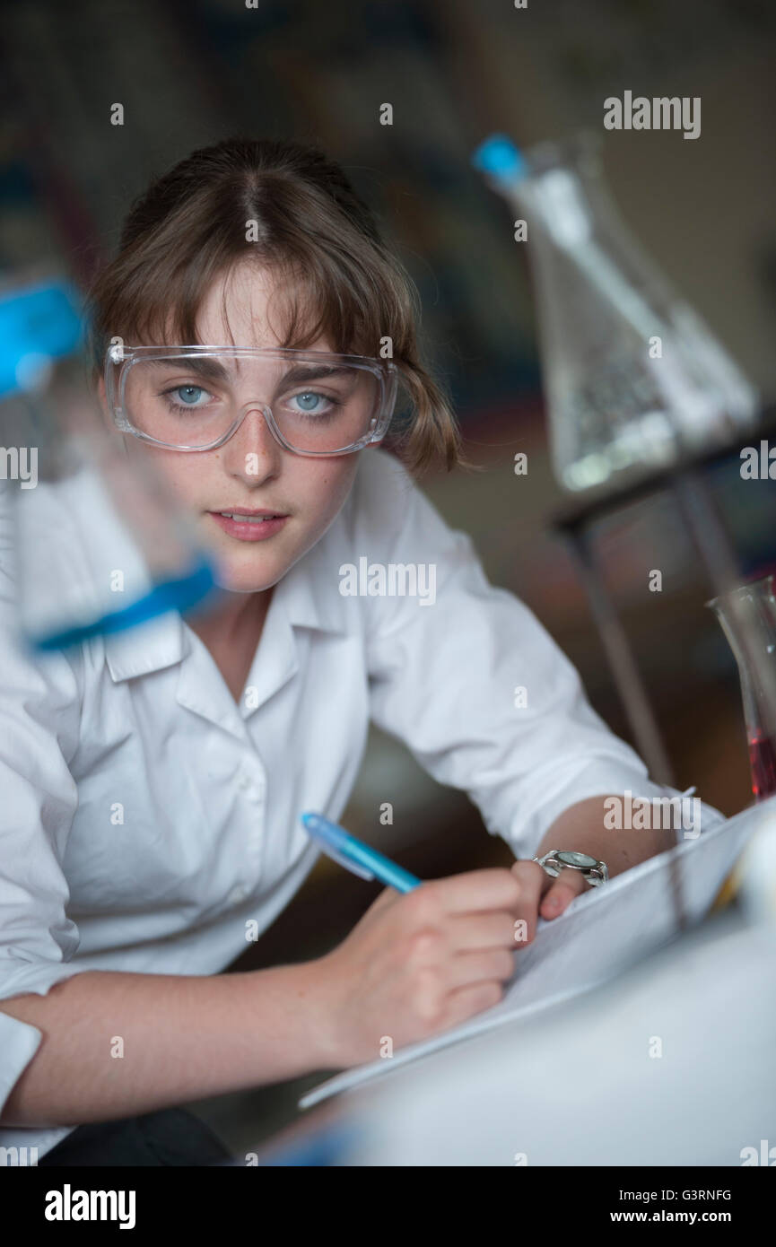 School science lesson pupil looking at a test tube beaker. England. UK ...