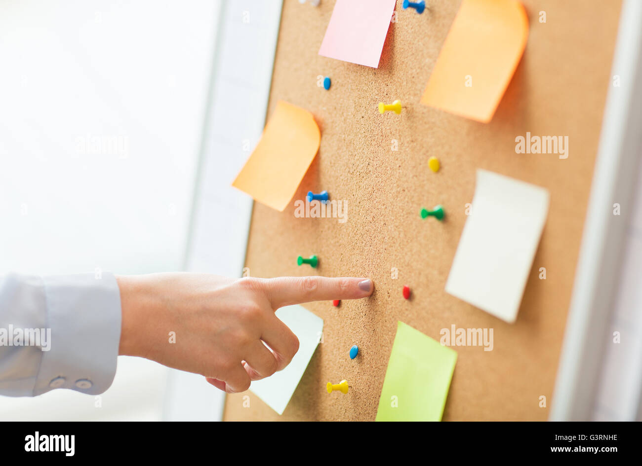 hand pointing to cork board with stickers and pins Stock Photo - Alamy