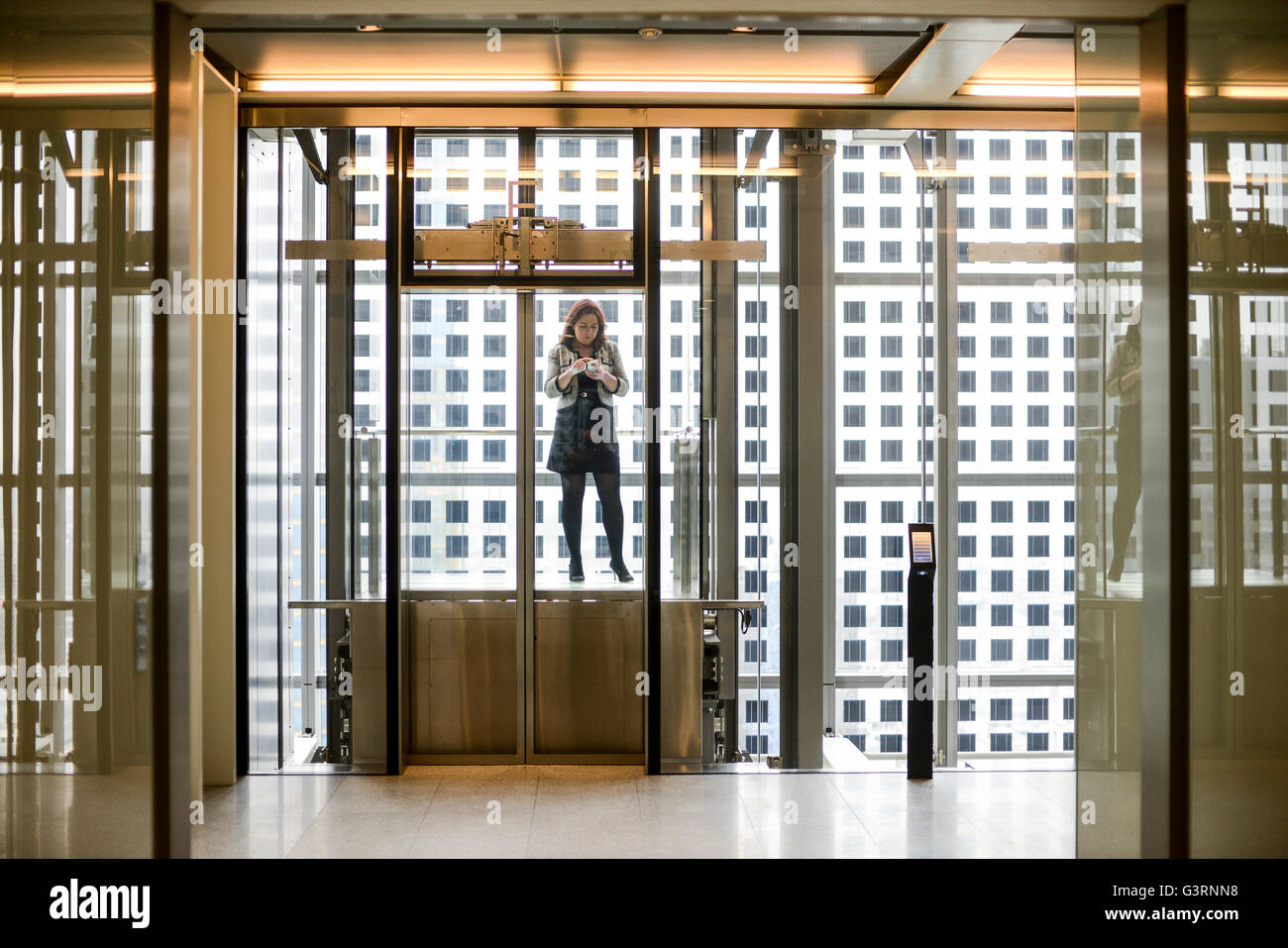 Woman in glass elevator/lift in modern office block Heron Tower Stock ...