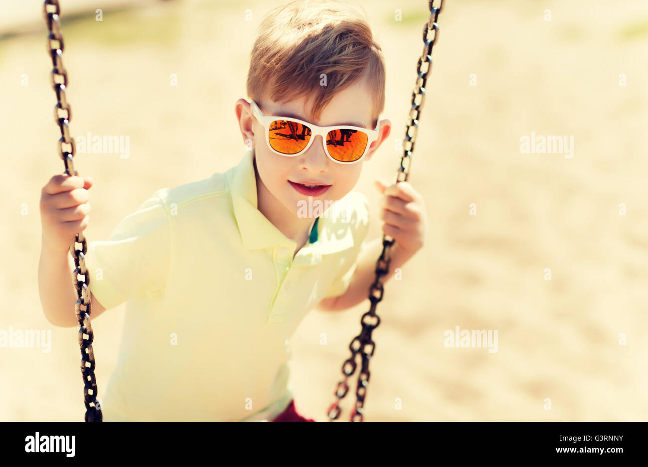 happy little boy swinging on swing at playground Stock Photo - Alamy