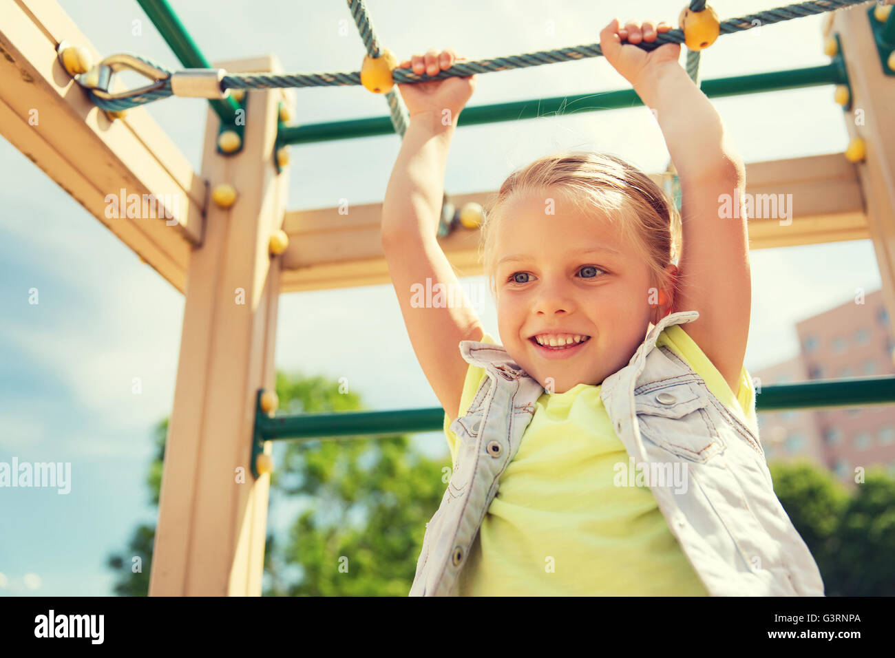 happy little girl climbing on children playground Stock Photo - Alamy
