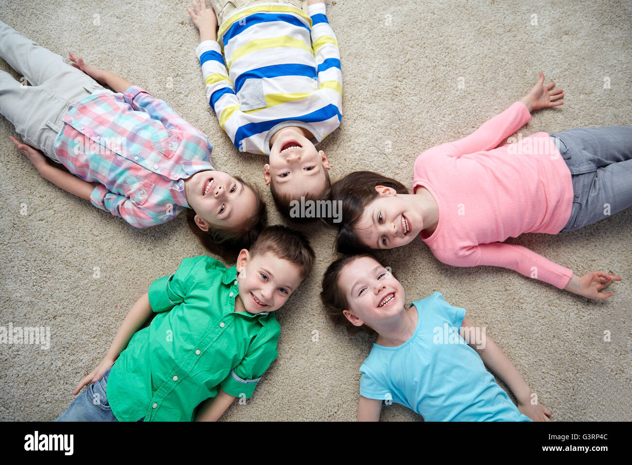 happy smiling little children lying on floor Stock Photo - Alamy