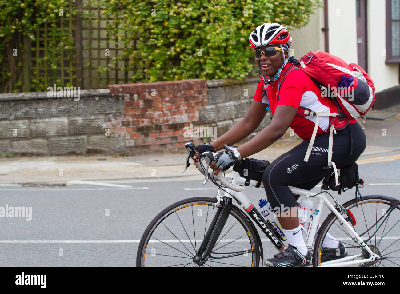 Young man in red top on white sports cycle Stock Photo - Alamy