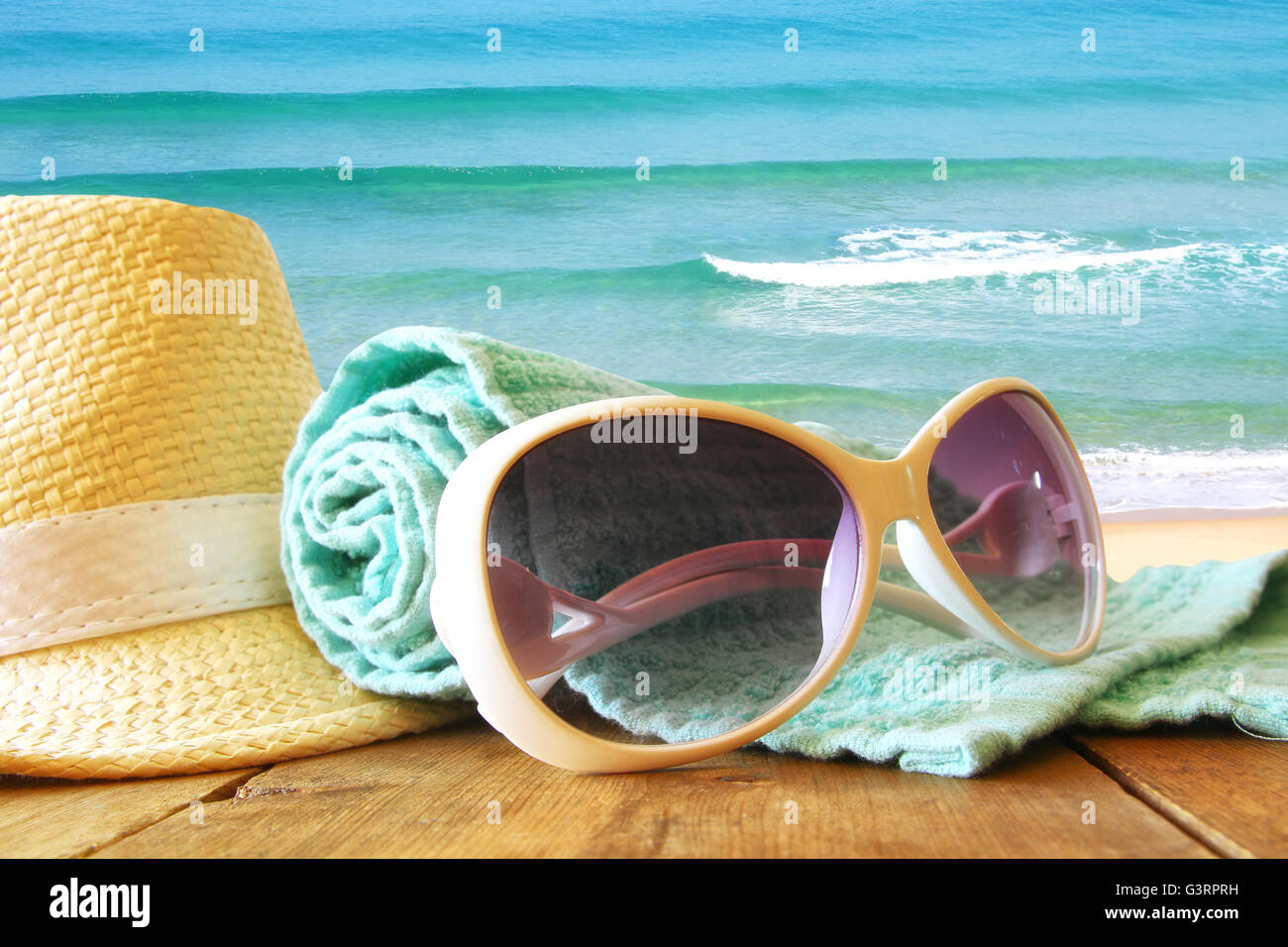 fedora hat and sunglasses over wooden table and sea landscape ...
