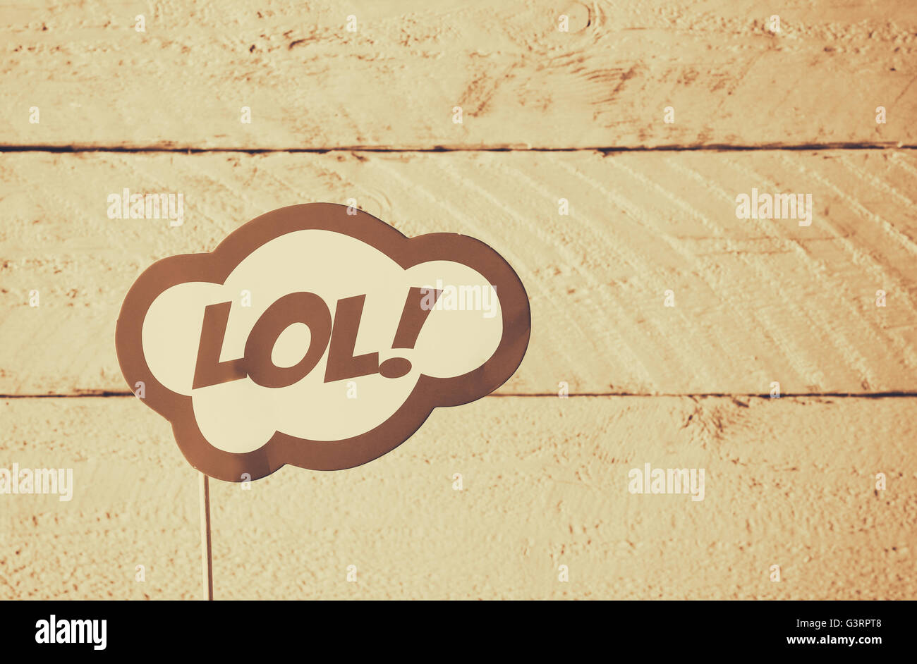 LOL bubble text comic retro sign, in front of wooden background. sepia ...
