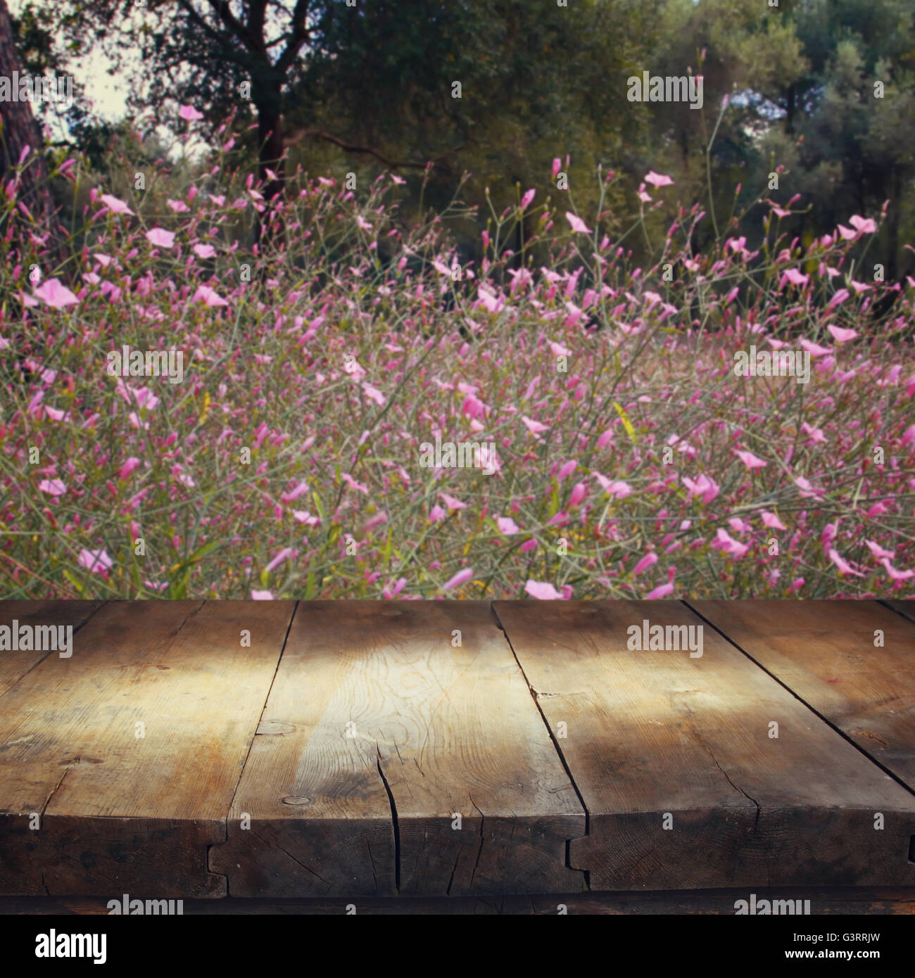 image of wooden table in front of flowers in forest background. vintage ...