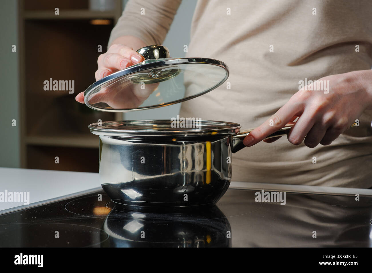 Person removing lid from cooking pot Stock Photo - Alamy