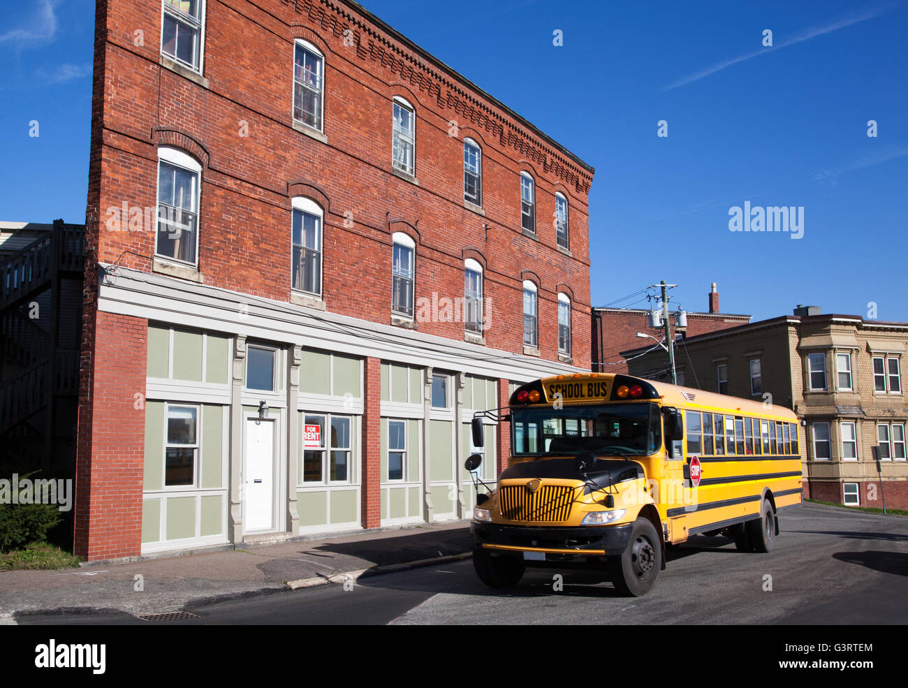 The school bus passing by flat shape building in Saint John town (New ...
