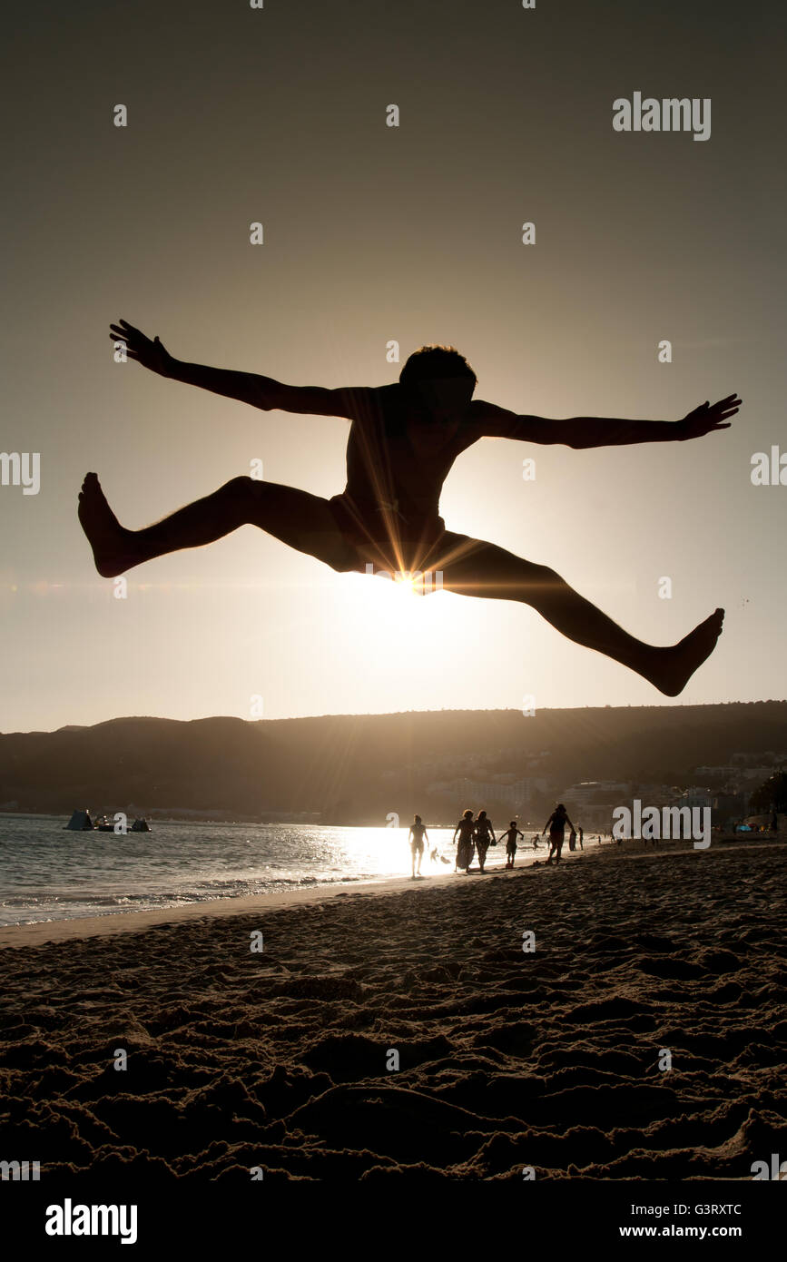 Teenage boy jumping high at the beach Stock Photo - Alamy