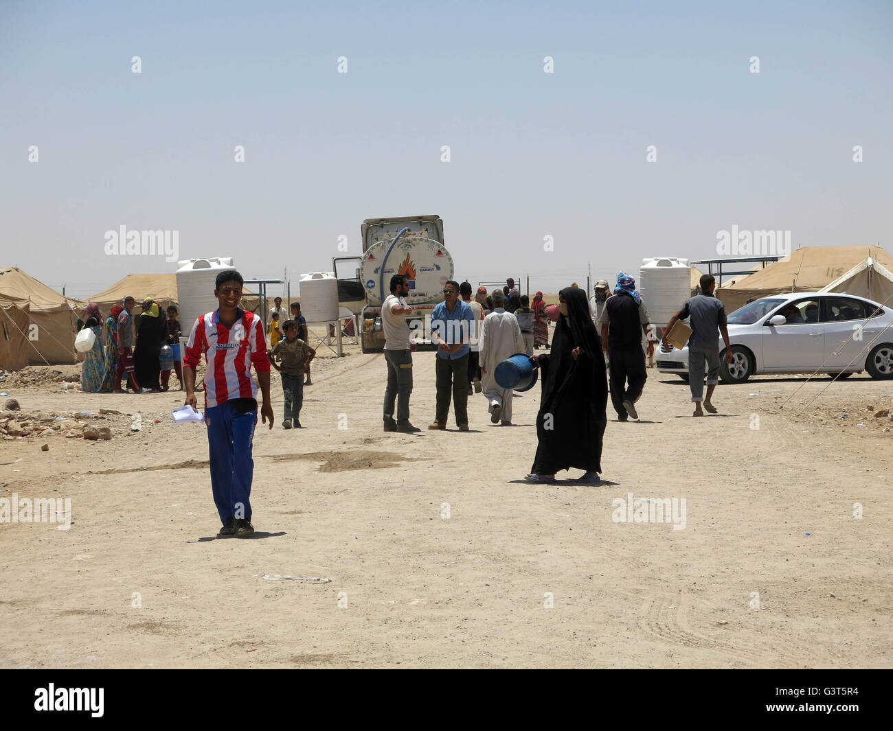 Fallujah. 14th June, 2016. People walk outside their tents in a camp ...