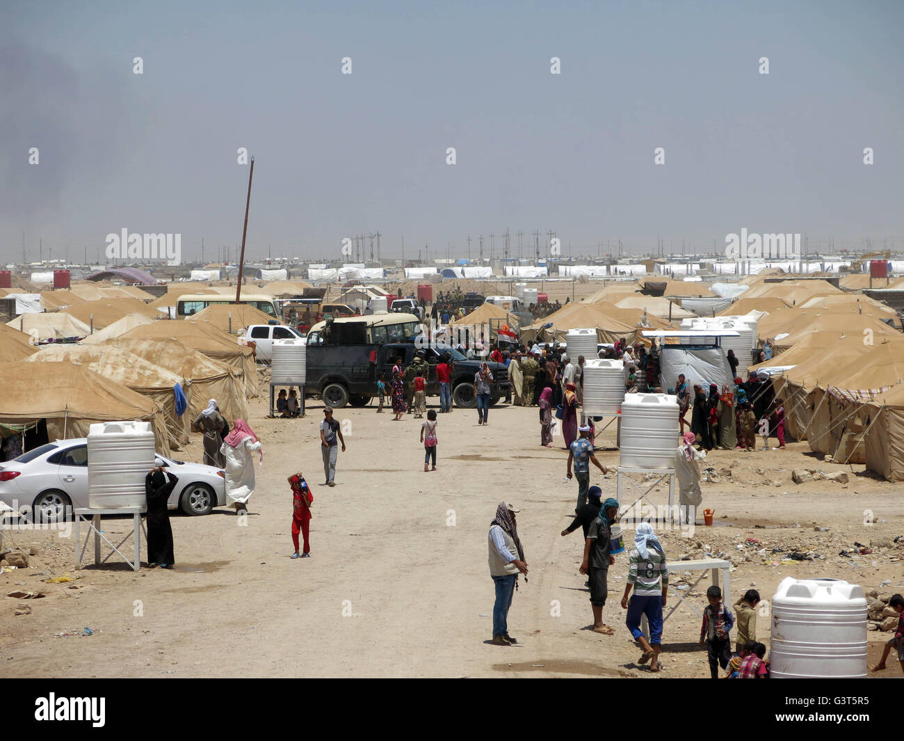 Fallujah. 14th June, 2016. People walk outside their tents in a camp ...