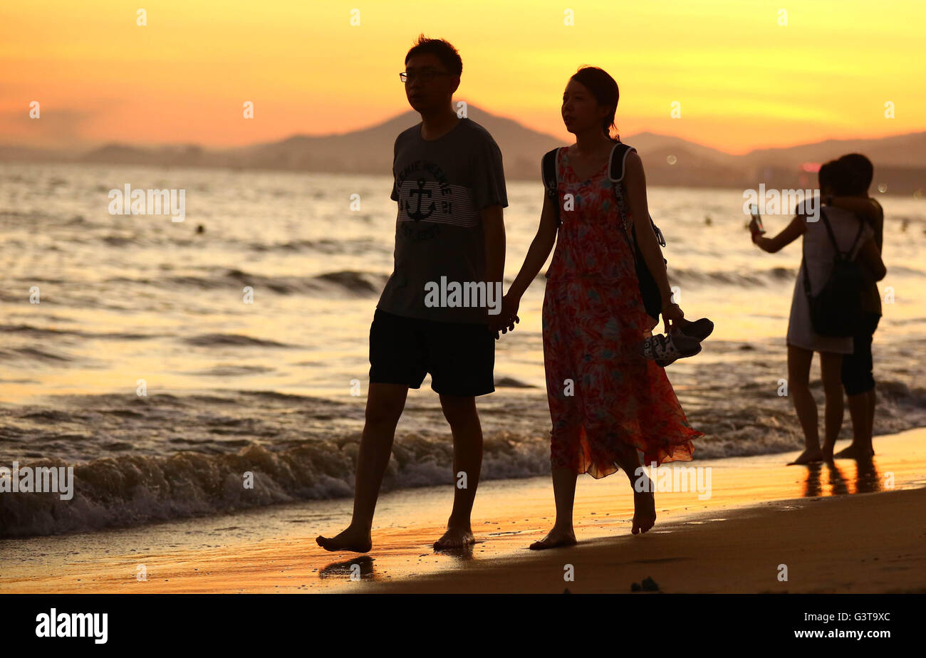 Sanya, China's Hainan Province. 14th June, 2016. People walk on a beach ...