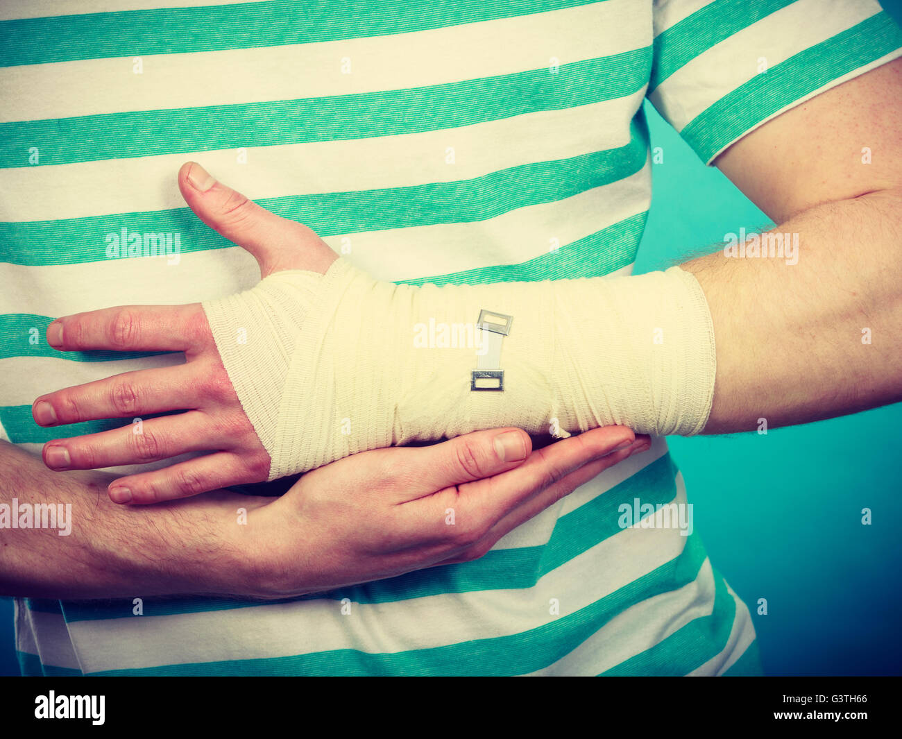 Pain and injury concept. Young man holds bandaged hand. Injured part of ...
