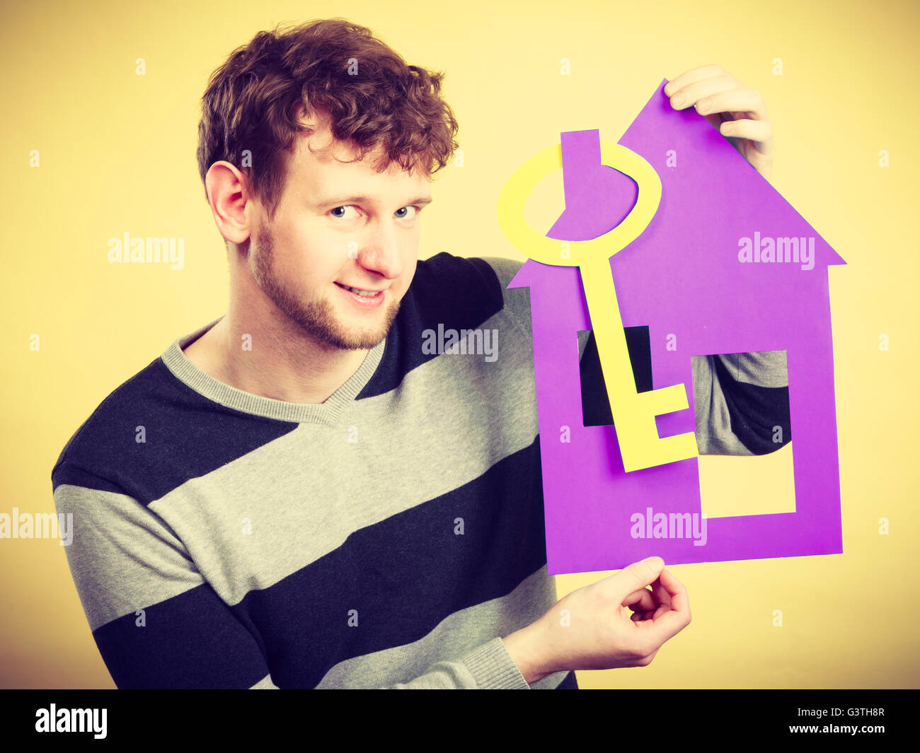 Good purchase concept. Male buyer with paper model of house and key ...