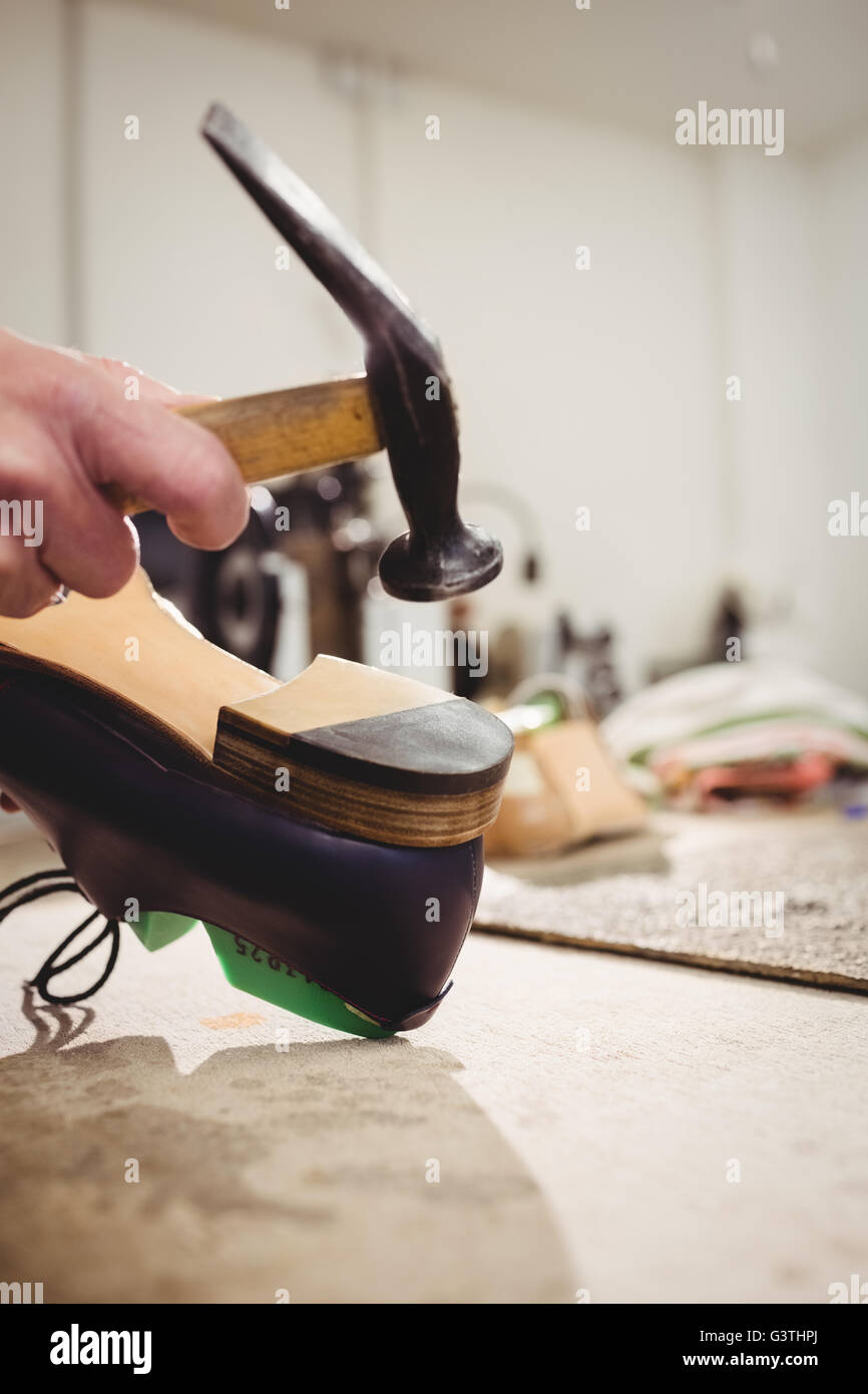 Close up of hand hammering on the heel of a shoe Stock Photo - Alamy