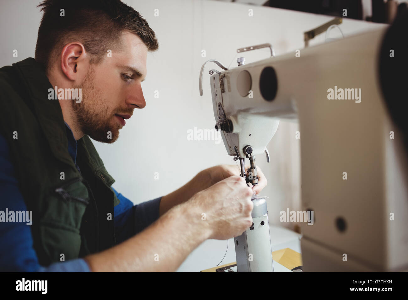 Profile view of cobbler using a sewing machine Stock Photo - Alamy