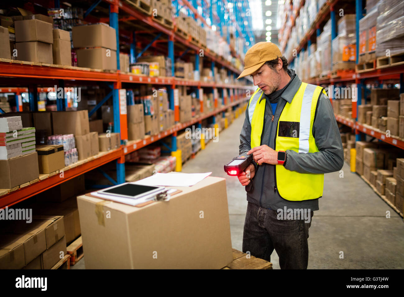 Warehouse worker using hand scanner in a warehouse Stock Photo - Alamy